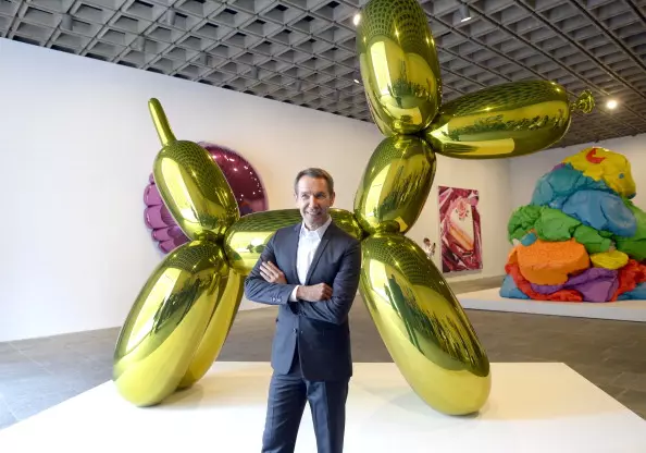 Artis Jeff Koons berpose di samping salah satu patungnya selama press preview of