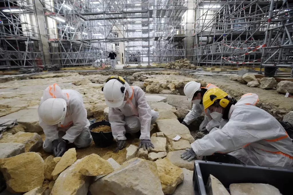 Abacukuzi b'ibyataburuwe mu matongo bacukuye hasi ya Katedrali ya Notre Dame nyuma yo kuvumbura sarcophagus yo mu kinyejana cya 14, i Paris, ku ya 15 Werurwe 2022. Ifoto ya Julien de Rosa / AFP ikoresheje amashusho ya Getty.