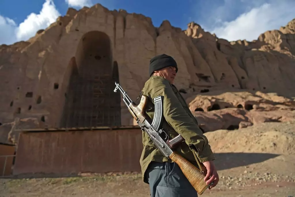 Op hierdie foto wat op 3 Maart 2021 geneem is, patrolleer 'n polisieman by die plek van die Boeddhas van Bamiyan-standbeelde, wat in 2001 deur die Taliban vernietig is, in die Bamiyan-provinsie. Foto deur WAKIL KOHSAR/AFP via Getty Images.