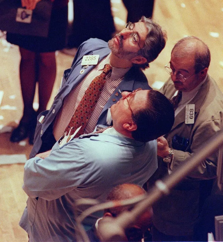 Handelaars op die vloer van die New York Aandelebeurs het die pryse in Januarie 1999 bewonder nadat die Dow Jones-nywerheidsgemiddelde op 'n rekordhoogtepunt geëindig het. (Foto: STAN HONDA/AFP via Getty Images)