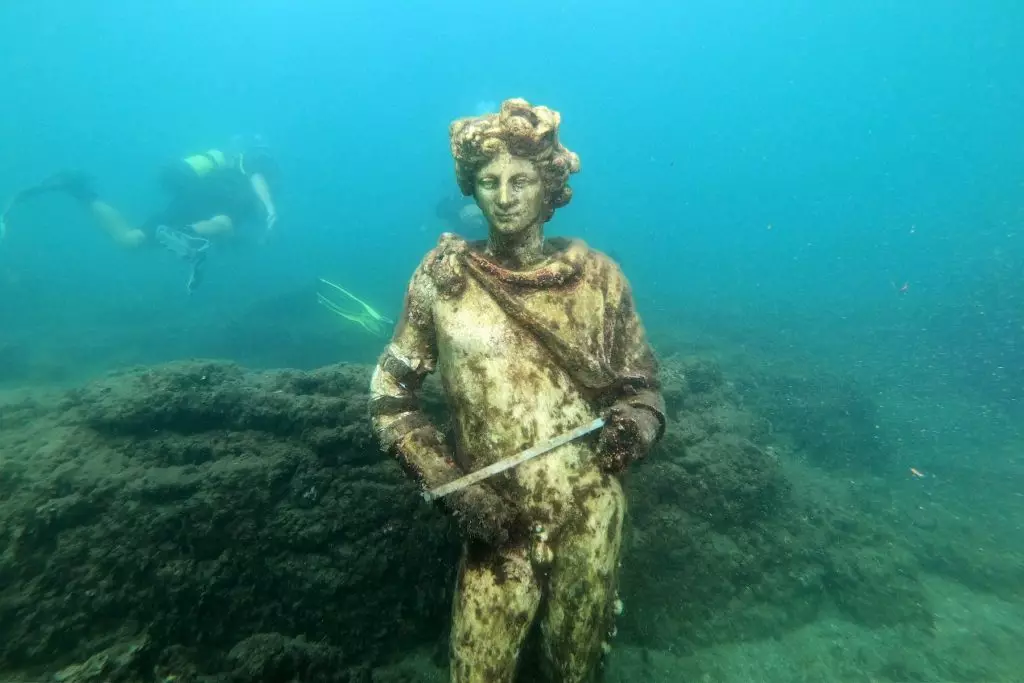 Uma cópia de uma estátua original, preservada no Museu de Baiae, de Dionísio, na antiga cidade romana submersa de Baia no Parque Arqueológico Subaquático de Baia, parte do complexo do Parque Arqueológico Campi Flegrei em Pozzuoli, perto de Nápoles. Foto de Andreas Solaro/AFP via Getty Images.