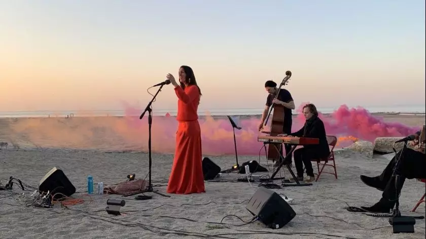 Ariana Vafadari, li Bîenaleya Bombay Beach, perçeyek operatîk, ku ji xwedawendek avê yê kevnar ê îranî îlham girtiye, dike. Wêne ji hêla Gregg Pichler ve bi xêrxwaziya Bombay Beach Biennale.