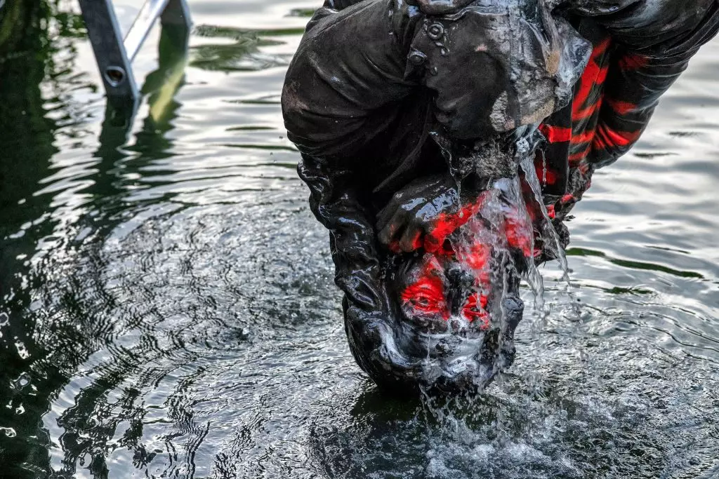 Patung pedagang budak Edward Colston dijupuk saka Pelabuhan Bristol dening tim penyelamat tanggal 11 Juni 2020 ing Bristol, Inggris. Foto dening Andrew Lloyd / Getty Images.