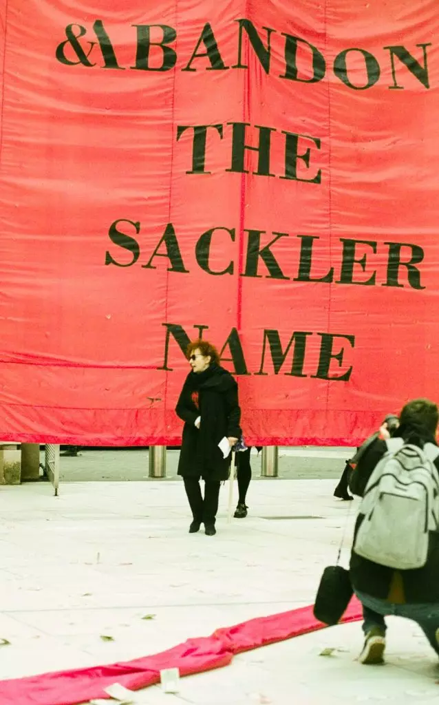 Nan Goldin protestanta kun Sackler P.A.I.N. ĉe la Victoria and Albert Museum en Londono en 2019. Foto de Lottie Maher, ĝentileco de Sackler P.A.I.N.