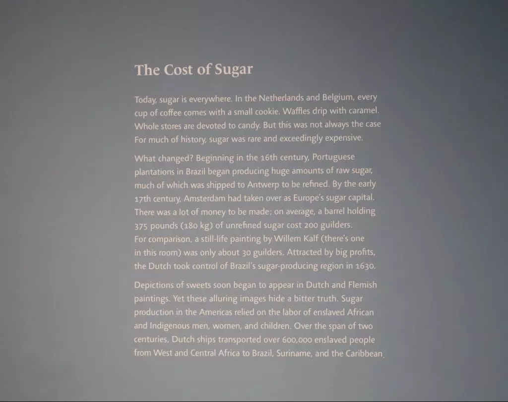 O etichetă de perete la MAE Boston care detaliază costurile globale devastatoare ale producției de zahăr. Foto: Menachem Wecker.