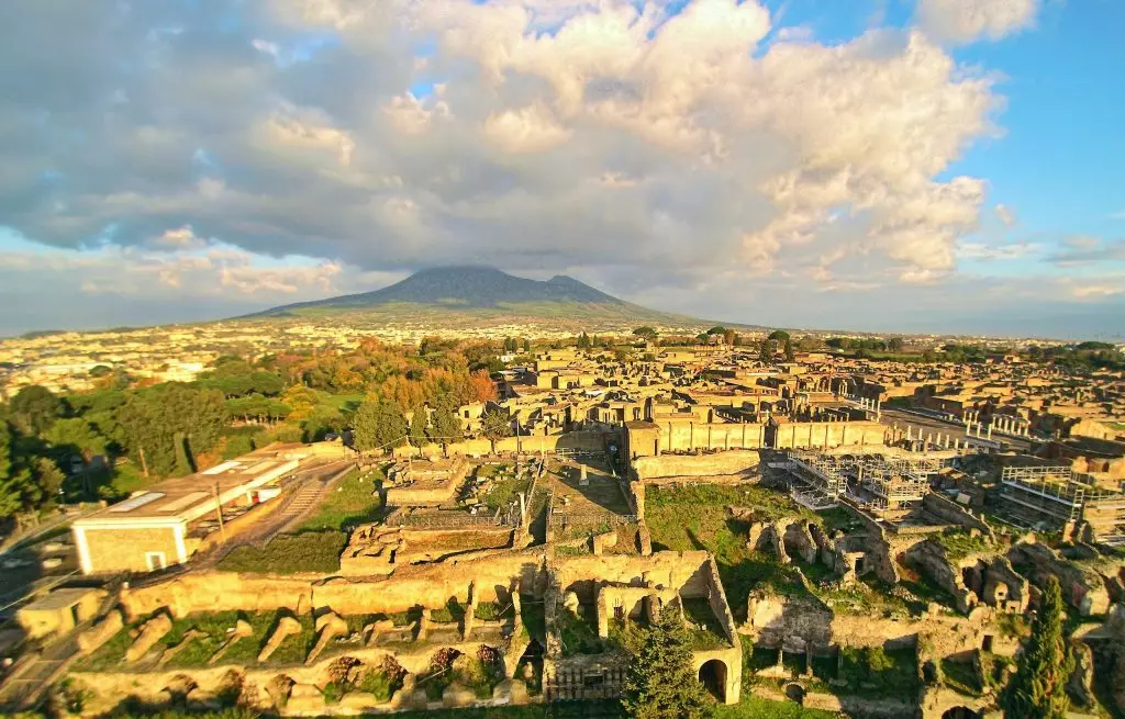 Mabwinja a Pompeii omwe amawonedwa kuchokera pamwambapa ndi drone, ndi Vesuvius kumbuyo. Chithunzi chojambulidwa ndi ElfQrin, laisensi ya Creative Commons Attribution-ShareAlike 4.0 International (CC BY-SA 4.0).