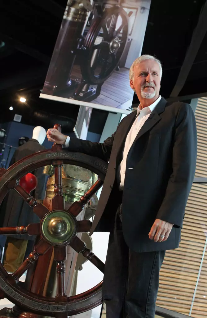 Den kanadiske filmregissøren James Cameron poserer ved siden av et skipshjul fra filmen 'Titanic' når han besøker Titanic Belfast Museum i Belfast, Nord-Irland, 7. september 2012. Cameron, regissør for den Oscar-nominerte filmen 'Titanic', og produsent John Landau åpnet den første utstillingen fredag dedikert til filmen på verdens største Titanic-museum, med rekvisitter og kostymer fra Camerons personlige samling. Foto av Peter Muhly/AFP/GettyImages)