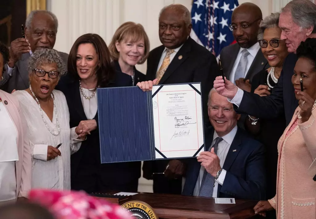 US Tus Lwm Thawj Coj Kamala Harris thiab Opal Lee (2nd L), tus neeg ua haujlwm hu ua Grandmother of Juneteenth, saib raws li Thawj Tswj Hwm Joe Biden tuav daim ntawv kos npe Juneteenth National Independence Day Act, nyob rau sab hnub tuaj ntawm Tsev Dawb, Lub Rau Hli 17, 2021, hauv Washington. Duab los ntawm Jim Watson / AFP ntawm Getty Images.