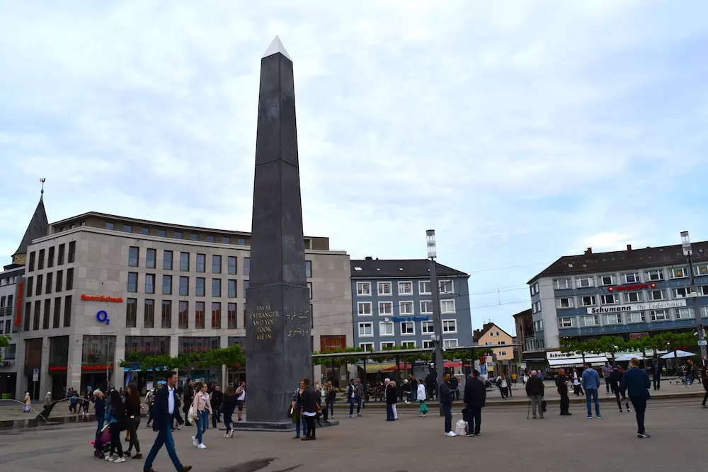 Monumento per stranieri e rifugiati di Olu Oguibe, con il versetto biblico