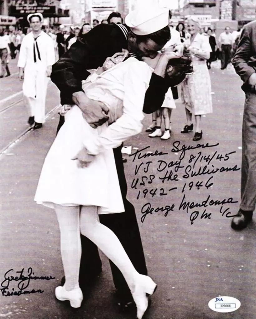 Kopja awtografata tar-ritratt ta’ Alfred Eisenstaedt ta’ Greta Zimmer Friendman qed tiġi bewsa minn baħri f’Times Square. Korteżija ta’ Joshua Friedman.