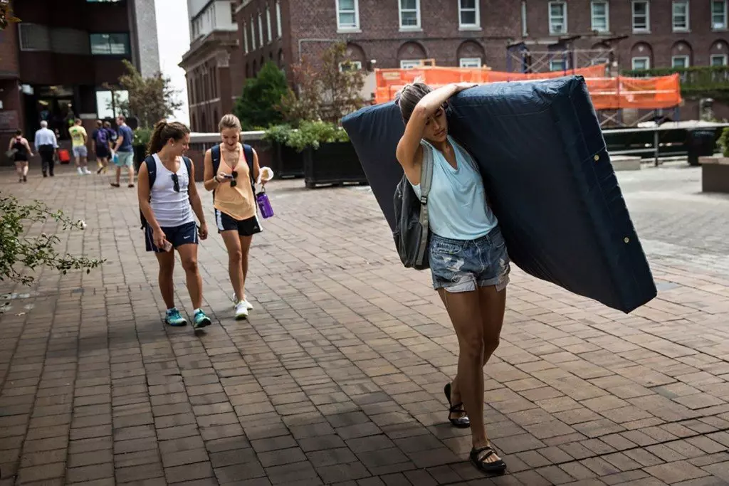 Emma Sulkowicz, estudante de artes visuais na Universidade de Columbia, leva un colchón en protesta pola falta de acción da universidade despois de que denunciara ser violada durante o seu segundo ano o 5 de setembro de 2014 na cidade de Nova York. Cortesía de Andrew Burton/Getty Images.