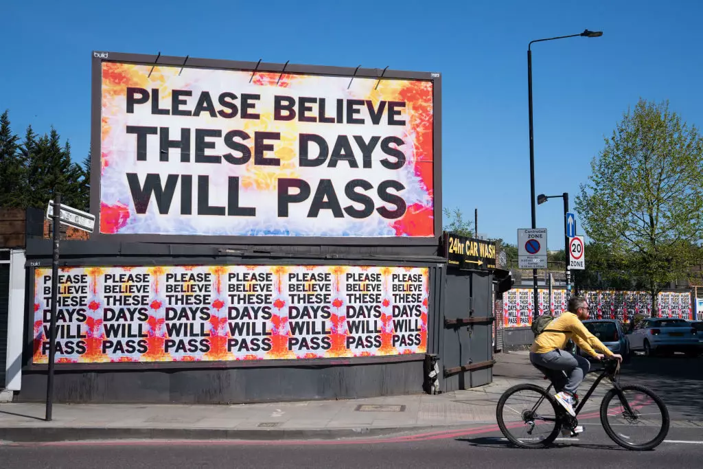 Šoredičā, Londonas austrumos, velosipēdists brauc garām stendam ar uzrakstu “lūdzu, ticiet, ka šīs dienas paies”. Dominika Lipinska / PA Images fotoattēls, izmantojot Getty Images.