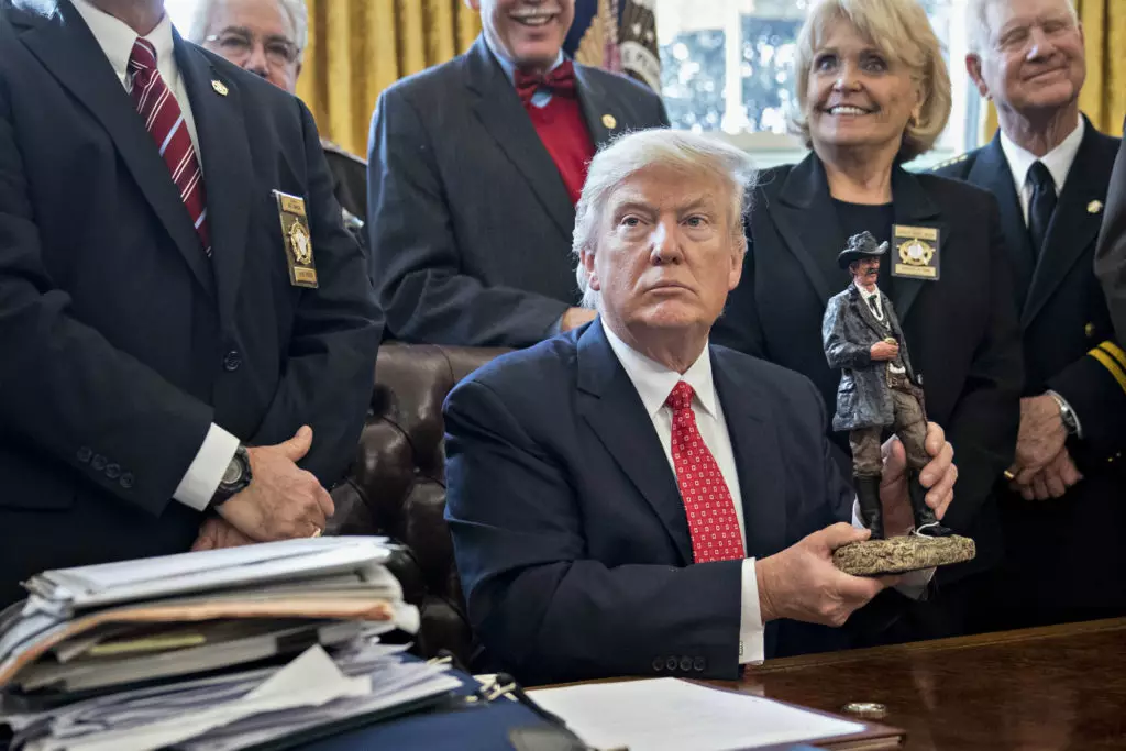 Hinahangaan ni US President Donald Trump ang isang estatwa na natanggap niya bilang regalo mula sa mga county sheriff, Pebrero 7, 2017. Larawan ni Andrew Harrer- Pool/Getty Images.