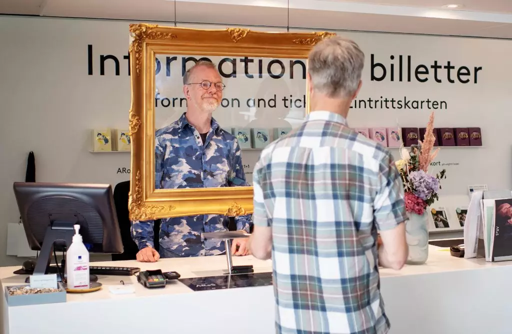 Seorang karyawan dilindungi oleh perisai di box office Museum Seni ARoS yang baru dibuka kembali di Aarhus, Denmark pada 22 Mei 2020. Foto oleh Bo Amstrup/Ritzau Scanpix/AFP via Getty Images.