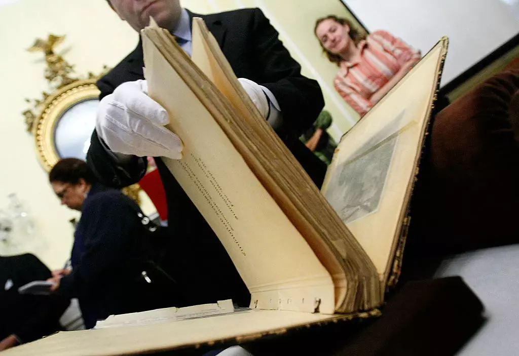 Un conservateur des Archives nationales françaises montre deux albums photo reliés en cuir documentant l'art qui a été pillé par les forces nazies pendant la Seconde Guerre mondiale. Photo de Win McNamee/Getty Images.