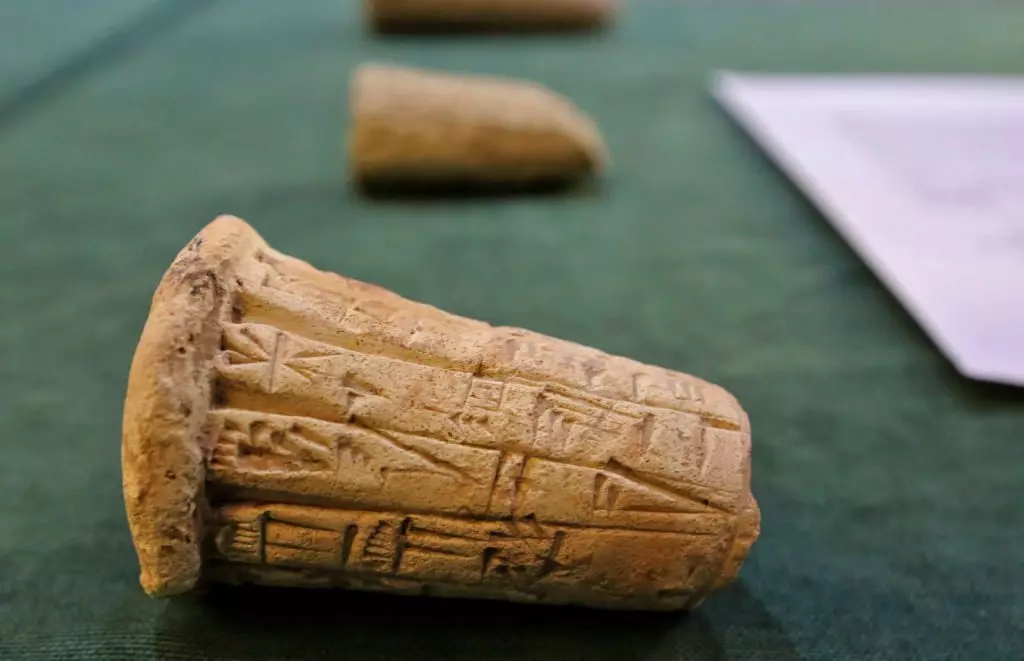 Cones de argila da Mesopotâmia com inscrições cuneiformes são exibidos durante uma cerimônia de entrega de um tesouro de antiguidades iraquianas saqueadas devolvidas pelos Estados Unidos, no Ministério das Relações Exteriores na capital Bagdá, em 3 de agosto de 2021. Foto de SABAH ARAR/AFP via Getty Imagens.