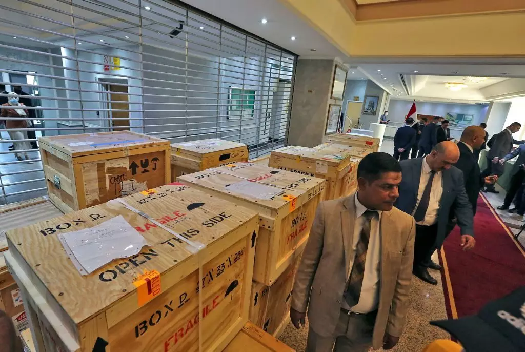 Ang mga kawani sa Ministry of Foreign Affairs sa Iraq nagtrabaho sa palibot sa mga crates sa gikawatan nga mga antiquities sa Iraq nga gibalik sa Estados Unidos, sa wala pa ang seremonya sa pagtugyan sa ministeryo sa kaulohan sa Baghdad, kaniadtong Agosto 3, 2021. Litrato ni SABAH ARAR/AFP pinaagi sa Getty Images.