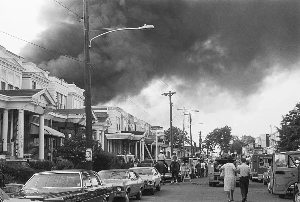 Rauch wabert über Reihenhäusern in West-Philadelphia, nachdem die Polizei das Haus der radikalen afroamerikanischen Organisation MOVE während einer Pattsituation bombardiert hatte, via Getty Images.