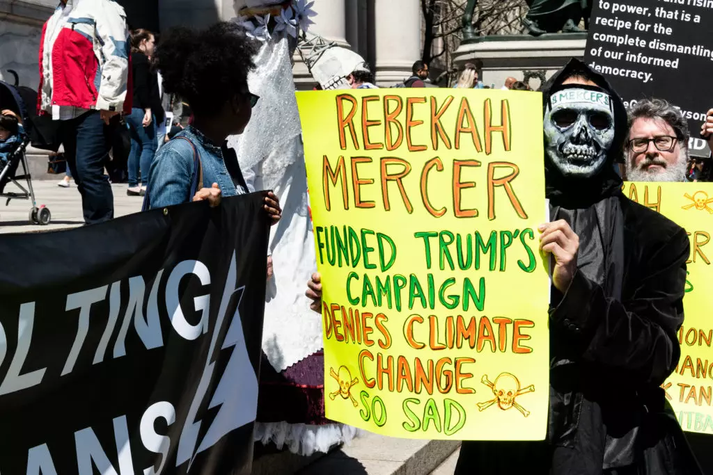 Mga demonstrador nga nagkupot og mga placard ug banner atol sa protesta batok kang Rebekah Mercer nga usa ka miyembro sa board of trustees sa American Museum of Natural History nga gipahigayon atubangan sa museum sa New York niadtong 2018. Litrato ni Michael Brochstein/SOPA Images/LightRocket/Getty Images .