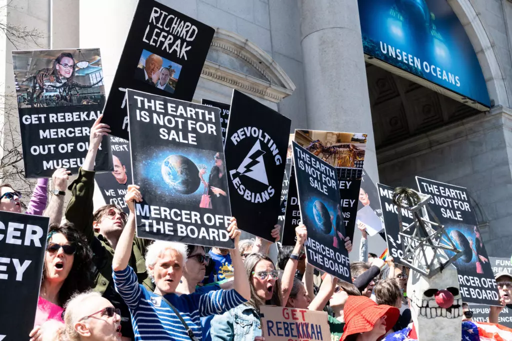 Mga demonstrador nga nagkupot og mga placard ug banner atol sa protesta batok kang Rebekah Mercer nga usa ka miyembro sa board of trustees sa American Museum of Natural History nga gipahigayon atubangan sa museum sa New York niadtong 2018. Litrato ni Michael Brochstein/SOPA Images/LightRocket/Getty Images .