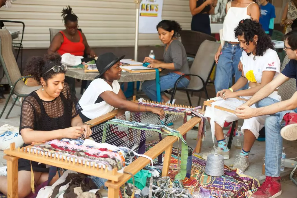 Membrii comunității care participă la o activitate de țesut în timpul unuia dintre atelierele Field Days din The Laundromat Project în 2017. Prin amabilitatea The Laundromat Project. Foto: Neha Gautam.