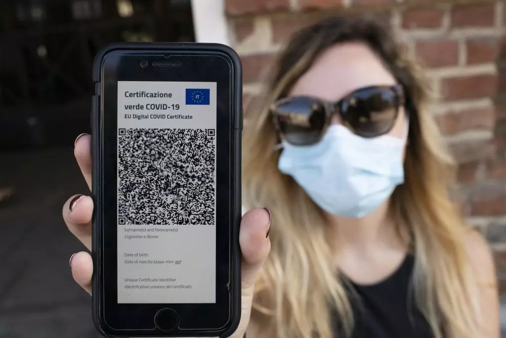 Eine Frau zeigt Italiens COVID-19 Green Pass für Reisen nach der Impfung am 30. Juni 2021 in Turin, Italien, auf einem Smartphone. Das digitale Gesundheitszertifikat oder Green Pass wurde offiziell vom italienischen Premierminister Draghi eingeführt und ermöglicht den Menschen den Zugang zu bestimmten Veranstaltungen und Einrichtungen in Italien sowie Reisen im In- und Ausland. Foto von Stefano Guidi/Getty Images.