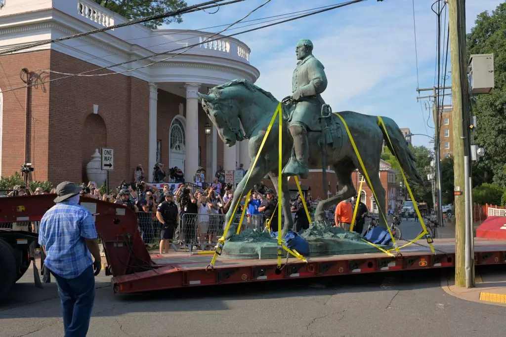 Statuo de konfederacia generalo Robert E Lee situanta en Charlottesvilles estas transportita for sur East Jefferson-strato post esti forigita de Market Street Park en Charlottesville, VA la 10-an de julio 2021. Foto: John McDonnell/The Washington Post per Getty Images.