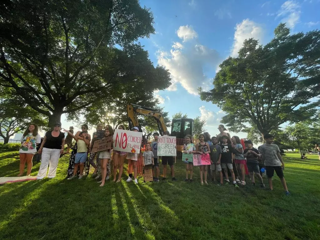 Lokala invånare och barn samlades i parken för att protestera mot byggandet av minnesmärken. Foto: Twitter.