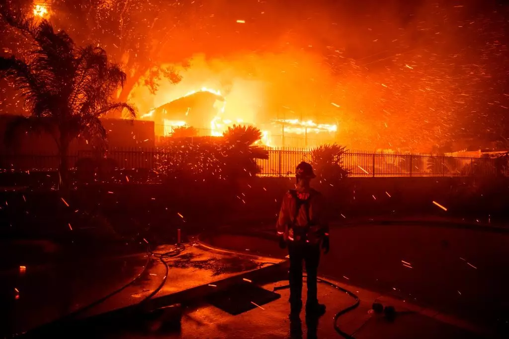 Nakatingin ang isang bumbero habang nasusunog ang mga bahay at umiihip ang mga baga sa panahon ng Hillside Fire sa North Park neighborhood ng San Bernardino, California noong Oktubre 31, 2019. (Larawan ni Josh Edelson / AFP) (Larawan ni JOSH EDELSON/AFP sa pamamagitan ng Getty Images)