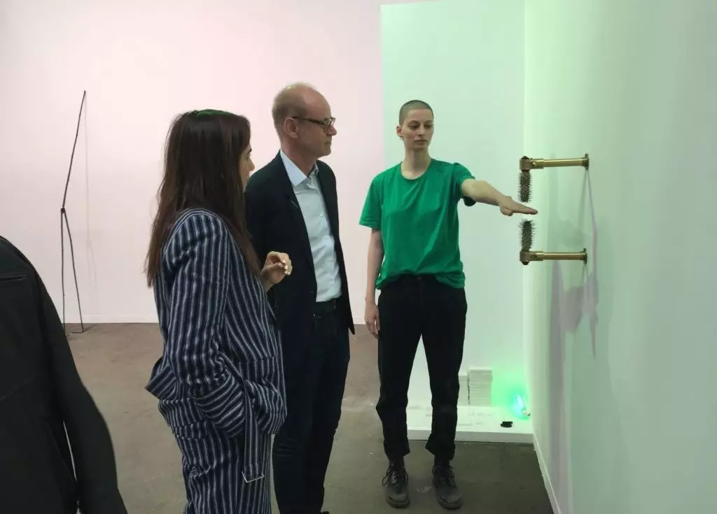 Frédéric de Goldschmidt kaj galeriisto Catinca Tabacaru observas prezentiston aktivigantan The Space in Between de Rachel Monosov (2019). Foto de Naomi Rea.