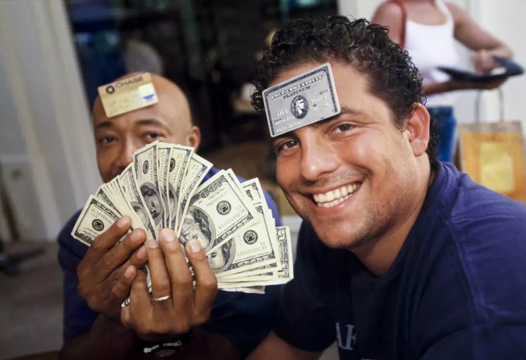 Sutradara lan produser film Brett Ratner (tengen), 29, lan Russell Simmons, 41, pengusaha lan pendiri label hip-hop Def Jam, ing restoran L'Iguane, St. Barts, 1998. Sawetara panyiapan ing pulo kasebut nampa kertu kredit. , lan pengunjung asring nggawa dhuwit akeh. © Lauren Greenfield.