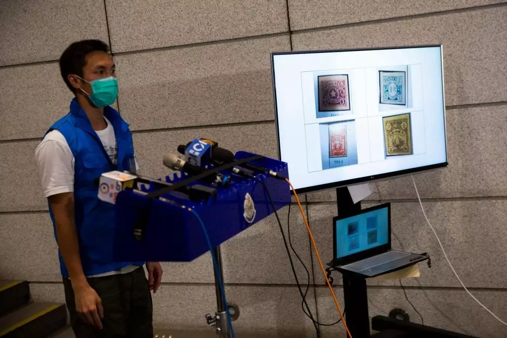 Amaphoyisa akhombisa isithombe sezitembu zakudala ezebiwe ngesikhathi kuqhubeka isithangami sabezindaba eHong Kong. Isithombe: Isaac Lawrence/AFP nge-Getty Images.