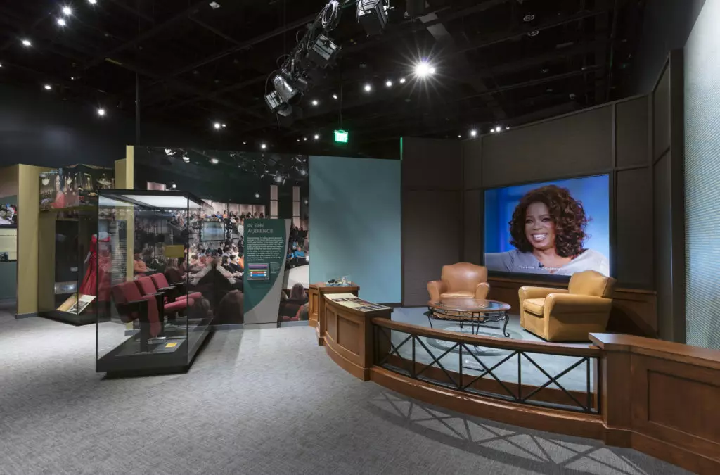 View enstalasyon "Watching Oprah: The Oprah Winfrey Show and American Culture" sou gade nan Smithsonian's National Museum of African American History and Culture. Foto koutwazi Mize Nasyonal Istwa ak Kilti Ameriken Afriken an.