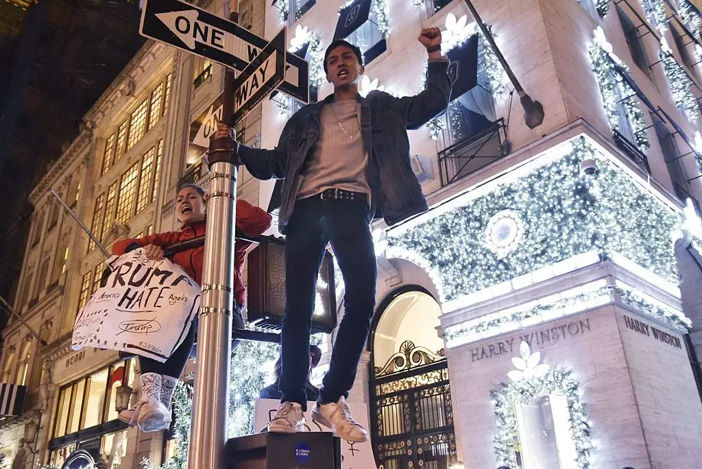 Demonstranten op engem Schëld ruffe Slogans wärend enger Demonstratioun op der 5th Avenue bei Trump Tower den 9. November 2016 zu New York, nodeems den Donald Trump als nächste President vun den USA gewielt gouf. Foto: Mandel Nigan/AFP/Getty Images.