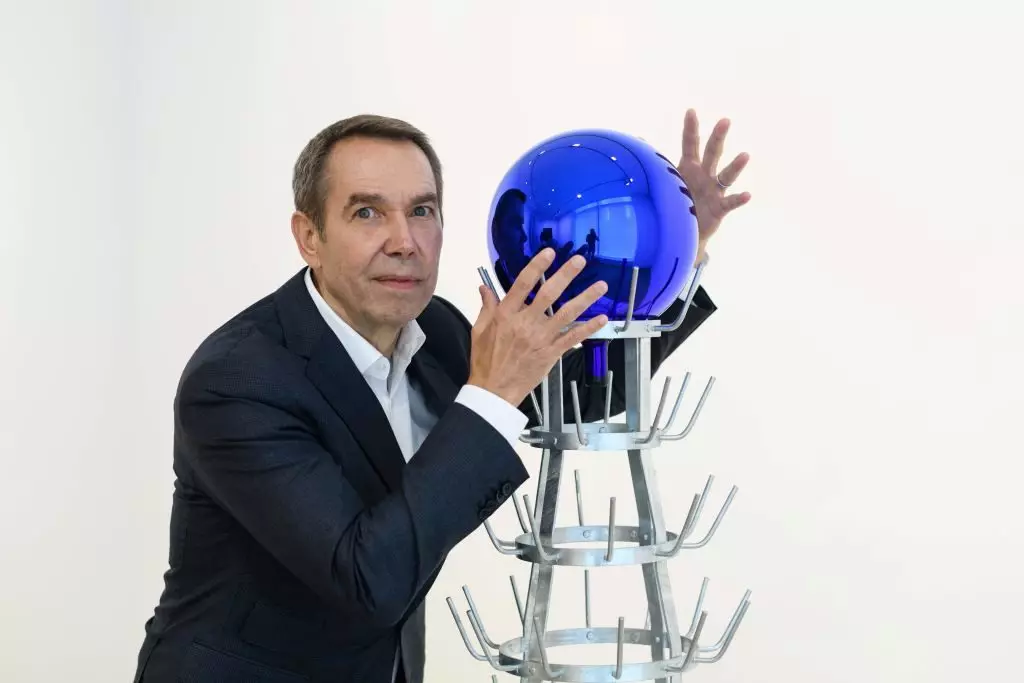 Jeff Koons posa com sua peça Gazing Ball (Bottlerack) (2016). Foto por Anthony Wallace/AFP/Getty Images.