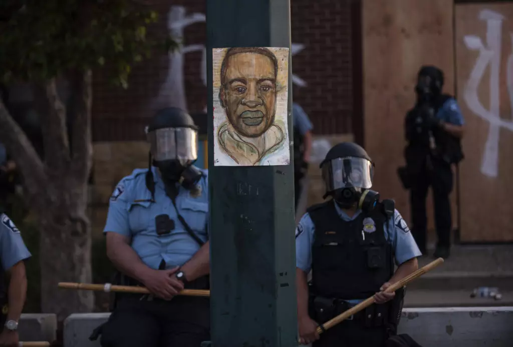 Portreto de George Floyd pendas sur stratluma fosto en Minneapolis, Minesoto. Foto de Stephen Maturen/Getty Images.