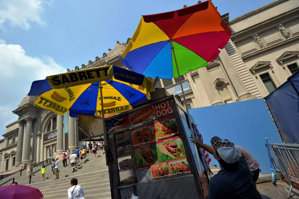 Un vendeur de hot-dogs plante un autre parapluie devant le Metropolitan Museum of Art de New York. Avec l'aimable autorisation de Stan Honda/AFP/Getty Images.