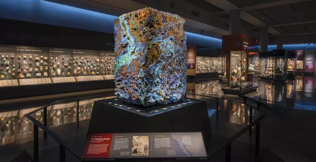 Coñecida como a Pedra Cantante, este enorme bloque de 4,5 toneladas de vibrante azurita azul e malaquita verde de Arizona foi exhibido por primeira vez na Exposición Mundial de Columbia de 1893 en Chicago. Despois de ser exposto por primeira vez no museo, este bloque foi denominado Pedra Cantante polos sons agudos que facía cando a humidade cambiaba co tempo e as estacións. Agora que se exhibe nun ambiente controlado, deixou de cantar. Foto de D. Finnin, ©Museo Americano de Historia Natural.