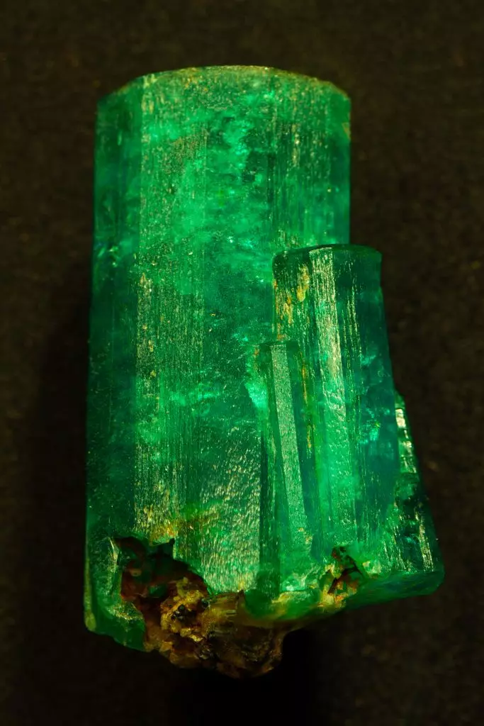 Criostail dé-heicseagánach, nó 12-thaobh, is ea an 632 carat Patricia Emerald agus meastar é ar cheann de na emeralds is mó ar domhan. Aimsíodh sa Cholóim i 1920 é, agus ainmníodh é i ndiaidh iníon úinéara an mhianaigh. Tá an t-eiseamal seo ar cheann den bheagán emeralds móra atá caomhnaithe gan ghearradh. Grianghraf le D. Finnin, © Músaem Meiriceánach Stair an Dúlra.