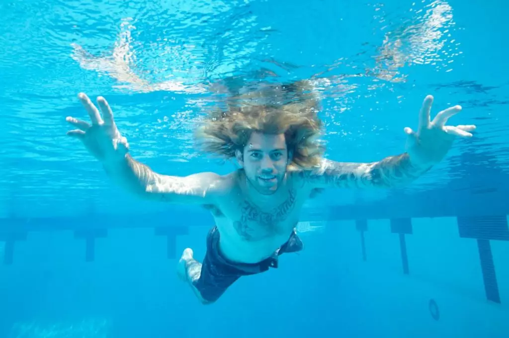 Spencer Elden recrea su pose de la portada del álbum Nevermind de Nirvana, fotografiada cuando era un bebé, 25 años después. Cortesía de John Chapple.