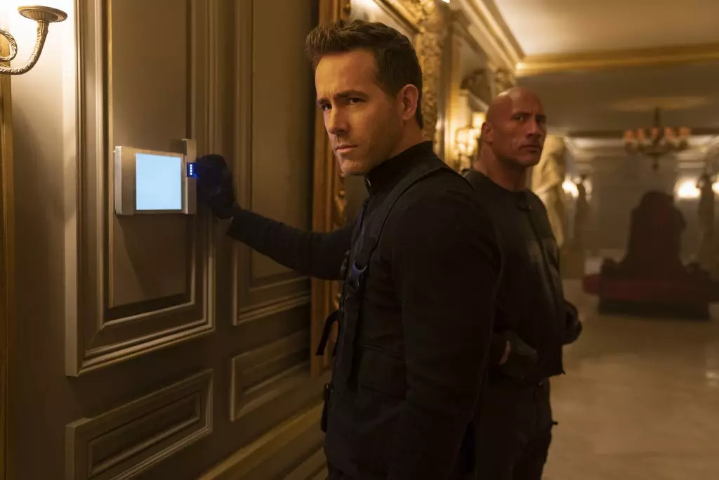 Ryan Reynolds estas Nolan Booth kaj Dwayne Johnson estas John Hartley en la Red Notice de Netflix. Foto de Frank Masi, ĝentileco de Netflix ©2021.