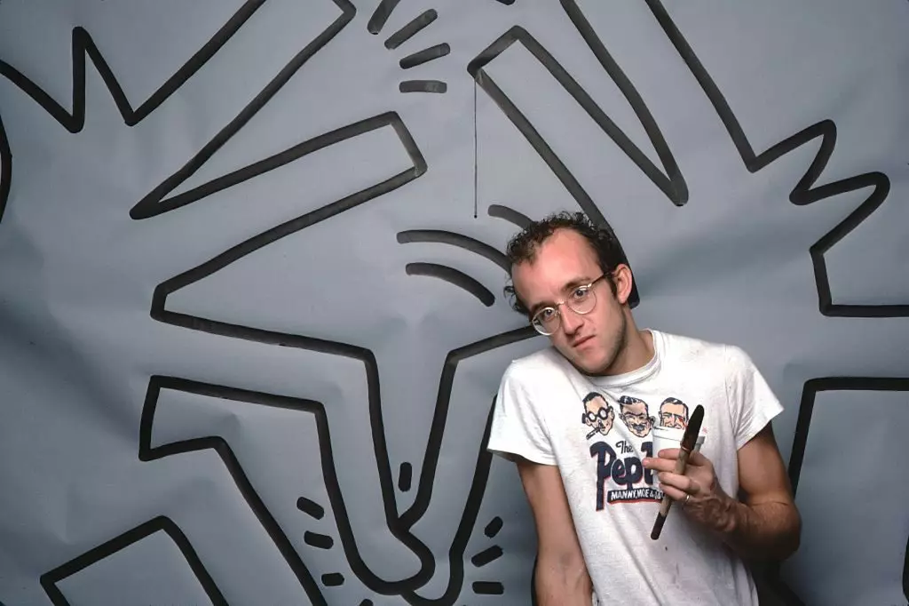 Keith Haring fotografato con uno dei suoi dipinti nell'aprile 1984. Foto di Jack Mitchell/Getty Images.