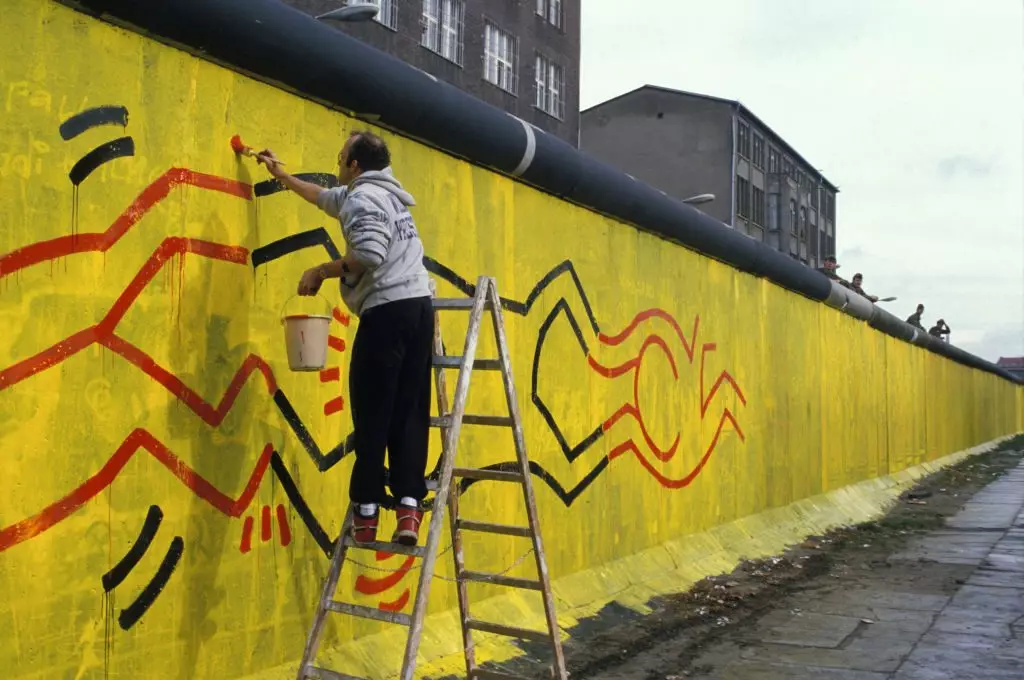 Keith Haring na-ese ihe osise na Berlin, Ọktoba 1986. Foto nke Patrick PIEL/Gamma-Rapho sitere na Getty Images.