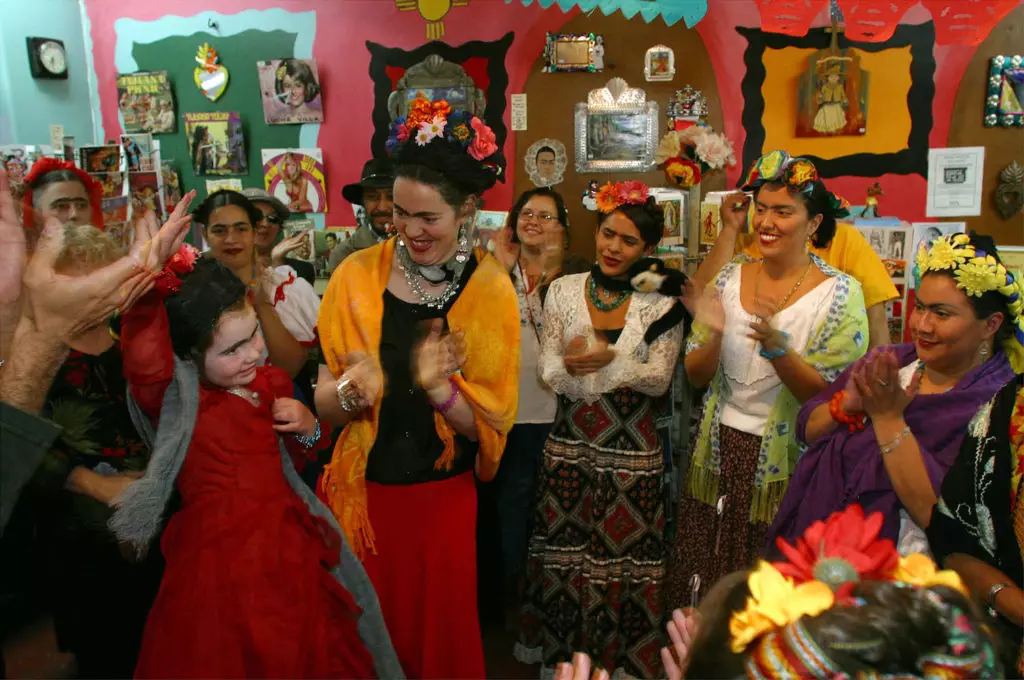 Ruby Alford (L) ndi amayi ake a Mary Rafferty (wachiwiri kuchokera ku L) avomereza kuwomba m'manja kwa anthu pamene apambana malo oyamba mumpikisano wowoneka ngati wa Frida Kahlo pa In Croud November 2, 2002 ku Albuquerque, New Mexico. Mwachilolezo cha Phillippe Diederich/ Getty Images.