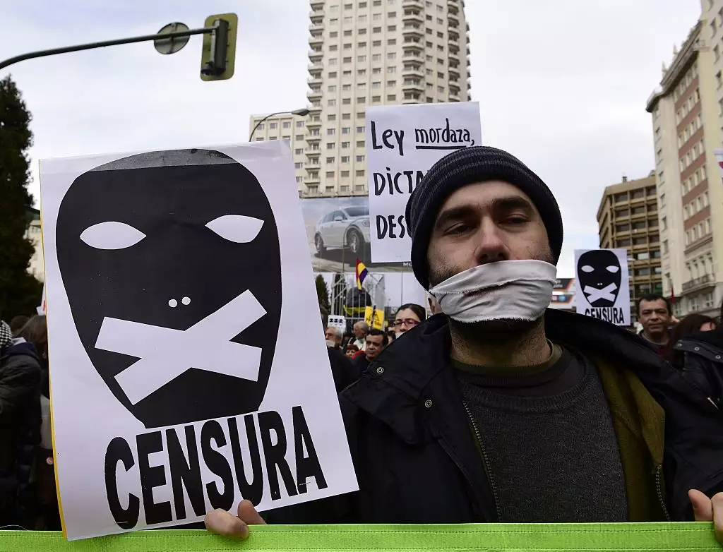 Un manifestante sostiene un cartel que dice