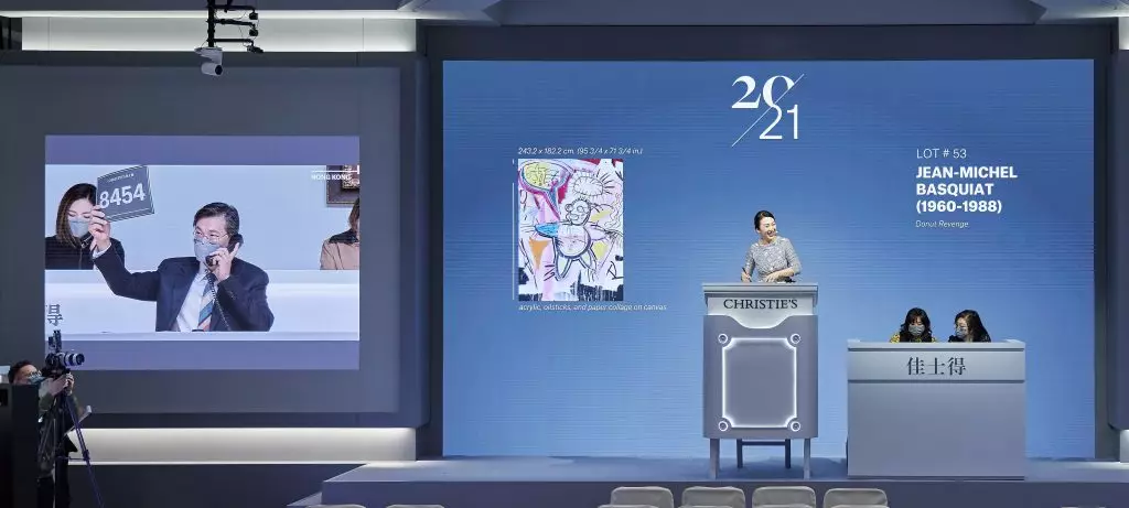 Auctioneer Elaine Kwok ngajual Jean-Michel Basquiat urang Donut Dendam ka bidder telepon digambarkeun ku Eric Chang, korsi Christie urang seni modern jeung kontemporer di Hong Kong. Kahadean tina Christie urang.