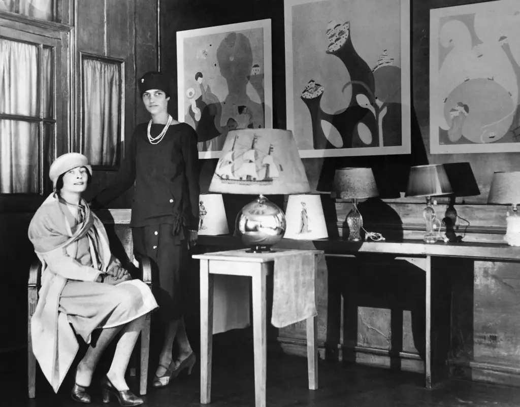 Peggy Guggenheim (sawv) nrog tus naas ej British artist Mina Loy hauv Paris. (Duab los ntawm George Rinhart / Corbis ntawm Getty Images)