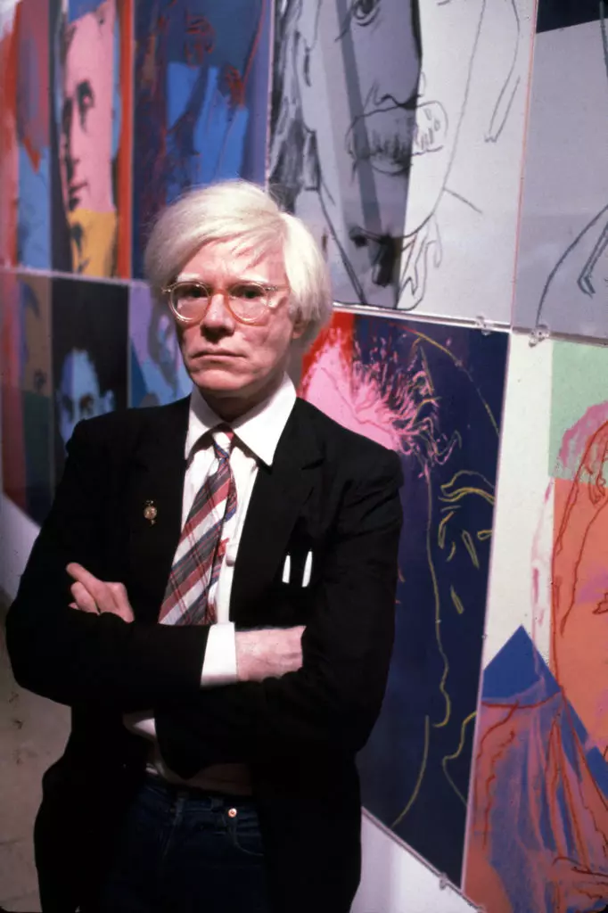 An t-ealaíontóir agus scannánóir Meiriceánach Andy Warhol lena phictiúir, 15 Nollaig, 1980. Grianghraf le Susan Greenwood/Gníomhaireacht Idirchaidrimh.