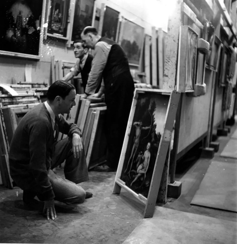 20 octobre 1942 : Sir Kenneth Clark (1903 -1983), directeur de la National Gallery, examine de près un tableau de la Collection Royale, "Adam et Eve" de Cranach, pour voir s'il a besoin d'être restauré. Photo Fred Ramage/Keystone Features/Getty Images.