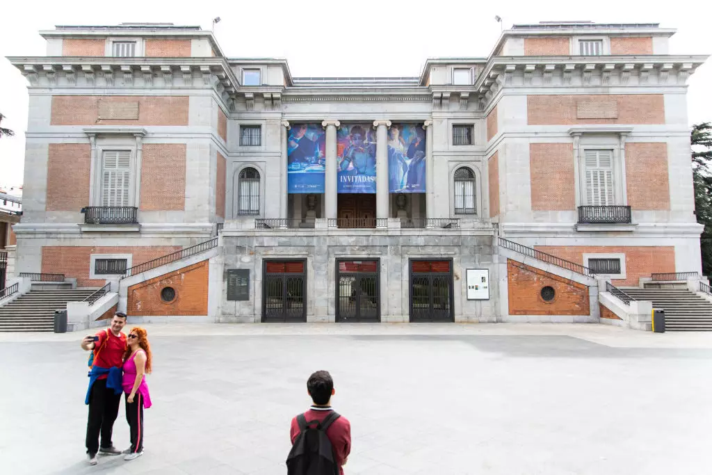 Yon nonm gade nan mize Prado fèmen pandan yon koup pran yon selfie nan Madrid, Espay. Foto: Patricia J. Garcinuno/Getty Images.